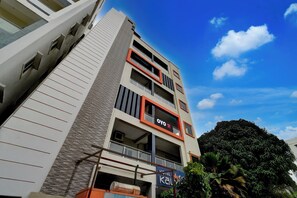 Um hotel de vários andares com design arquitetônico moderno, com varandas e um letreiro de hotel bem visível.