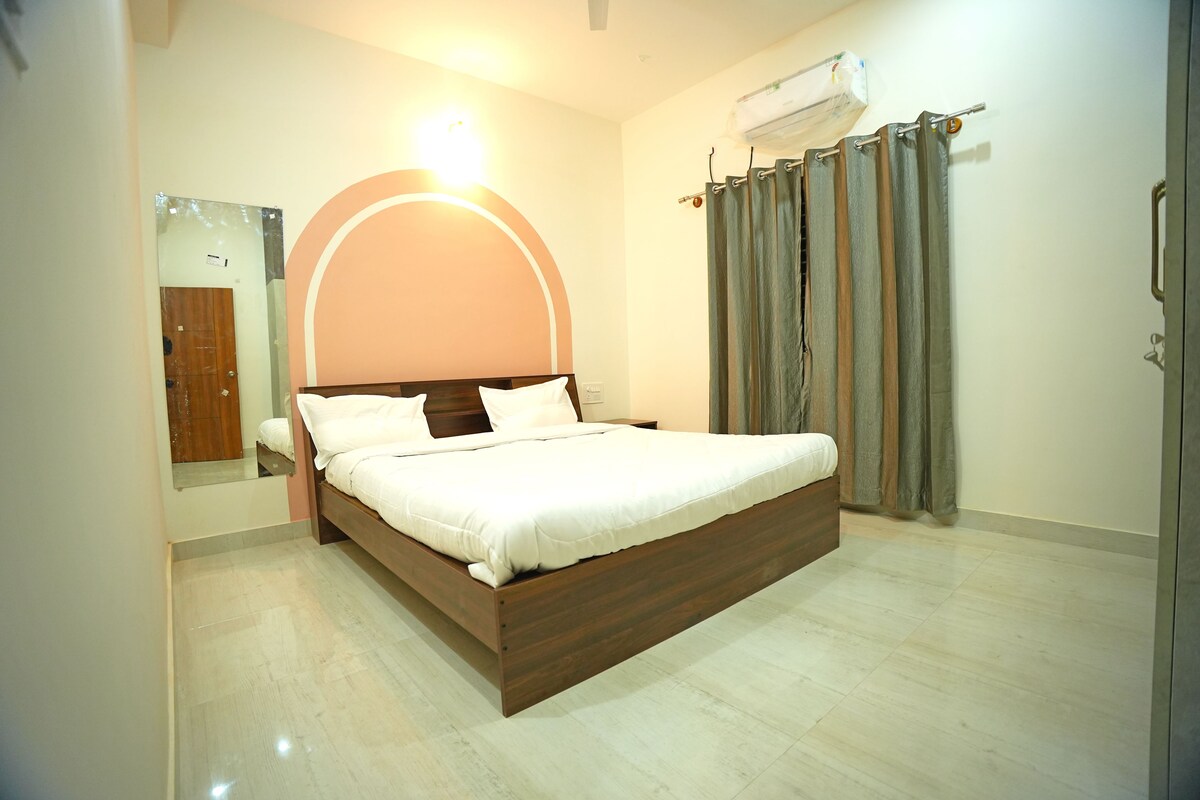 Quarto com cama, espelho, ar condicionado fixado na parede e cortina.