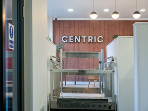 Uma cozinha comercial com bancada de aço inoxidável e uma placa com a inscrição 'CENTRIC'.