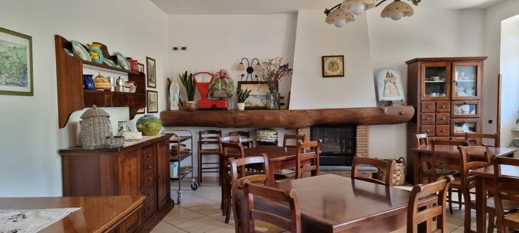 Uma sala de jantar com mesa e cadeiras de madeira, lareira e um armário com louças.