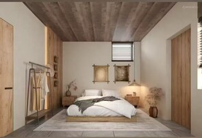 Quarto com cama, mesas de cabeceira, guarda-roupa, cabideiro e janela.