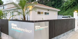 Edifício de resort com uma placa indicando 'KRbase villa Izu Shirahama Resort'.