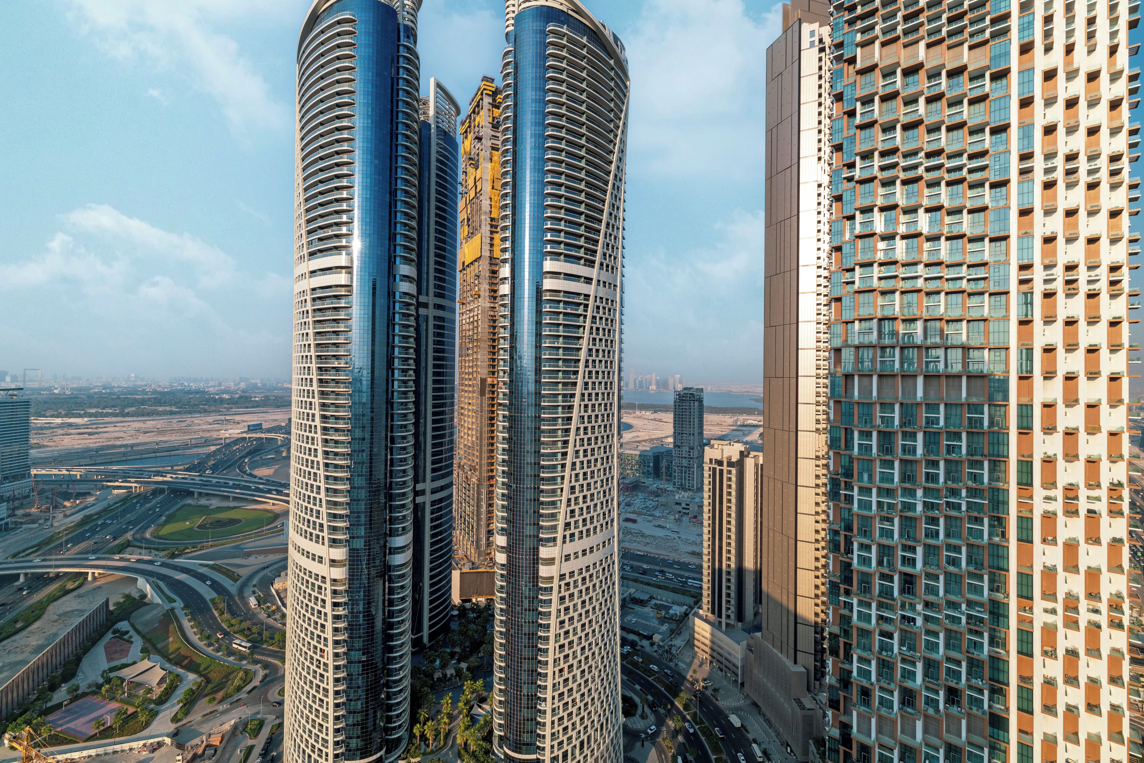 Um edifício alto com fachada curva e várias varandas.