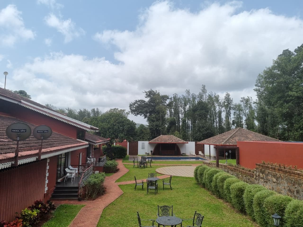 Hotel com piscina, área de estar externa e espaço coberto.