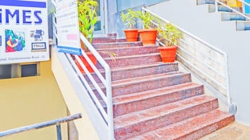 Escadas externas com corrimão que levam à entrada de um edifício.
