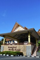 Um edifício com uma placa indicando 'Kudat Golf & Marina Resort'.