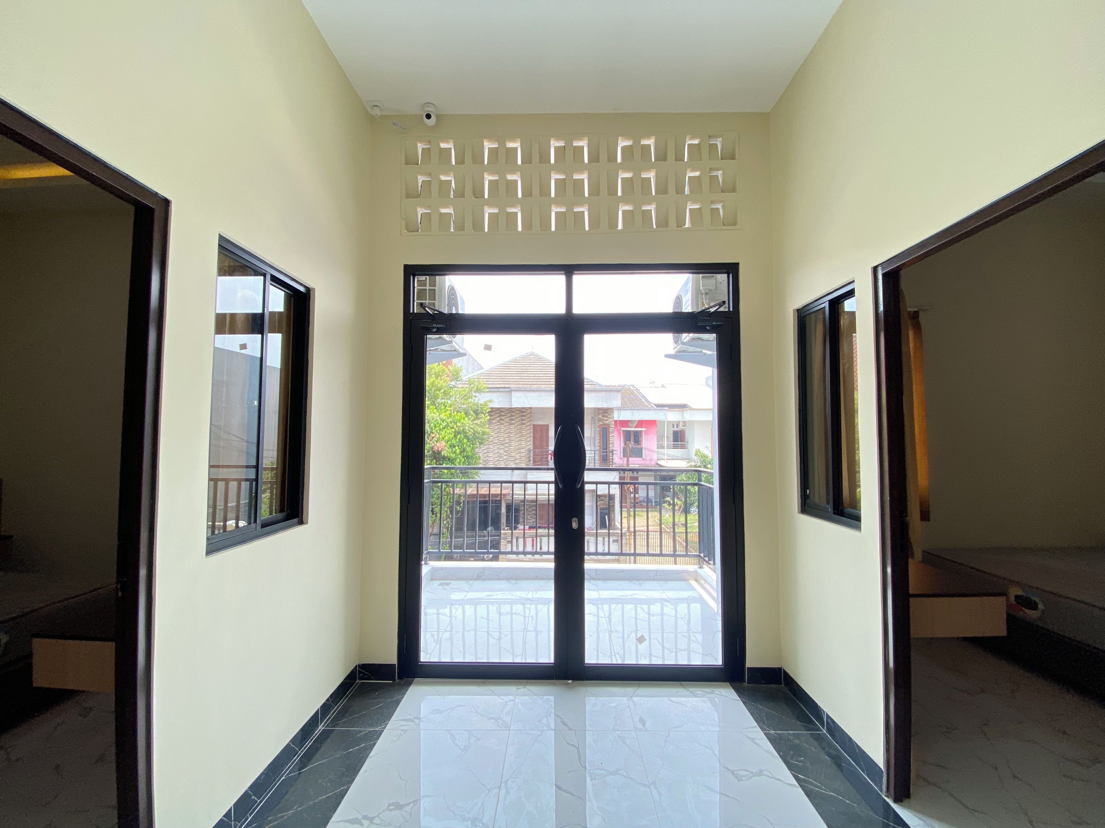 Um corredor com porta de vidro que dá para uma varanda.