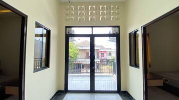 Um corredor com porta de vidro que dá para uma varanda.