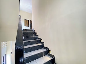 Escadaria com degraus de mármore preto e design moderno.