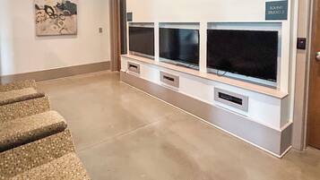 Quarto com área de estar, televisão fixada na parede e placa com a inscrição 'SOUND STUDIO 2'.