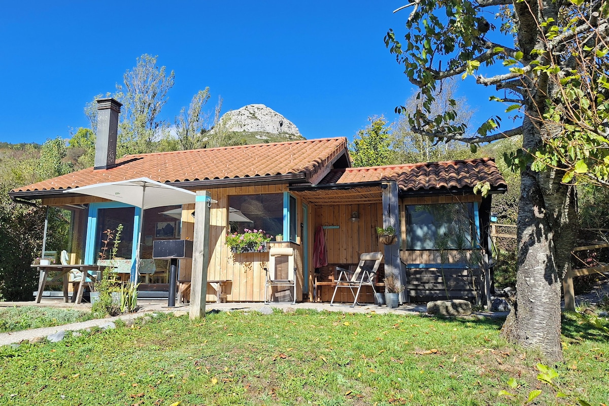 Uma cabana de madeira com telhado de cerâmica, alpendre coberto e lareira de pedra.