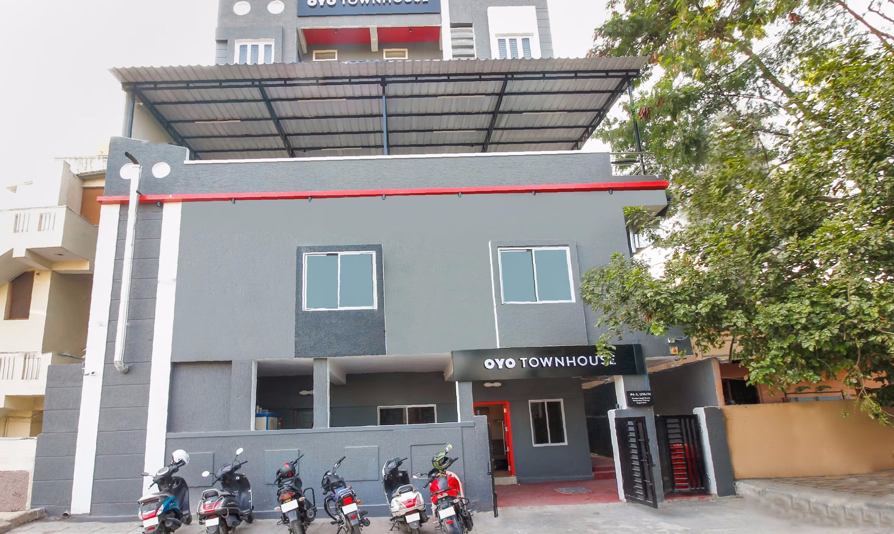 Um prédio de dois andares com uma placa que diz 'OYO TOWNHOUSE'.