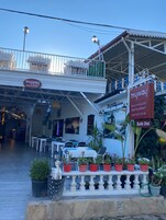 Restaurante chamado 'myway' com área externa e placa anunciando quartos na praia.