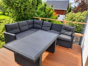 Sofá modular com mesa combinando numa varanda.