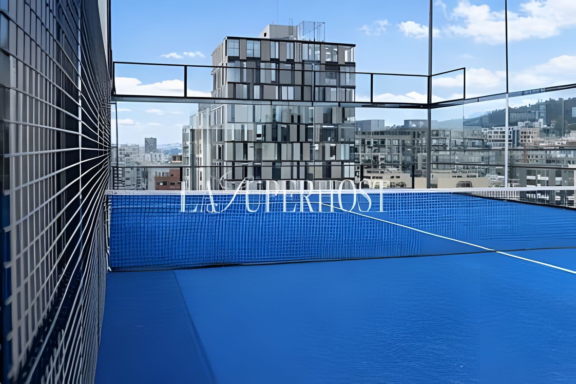 Um edifício moderno com fachada de vidro e área de piscina no terraço.