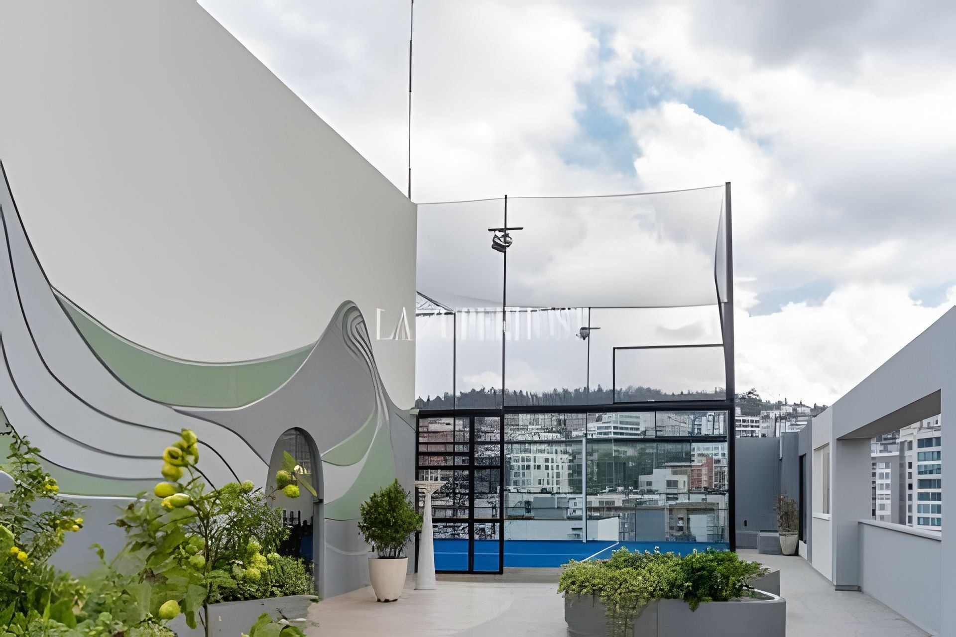 Um edifício moderno com fachada curva, janelas amplas e vista para a paisagem urbana.
