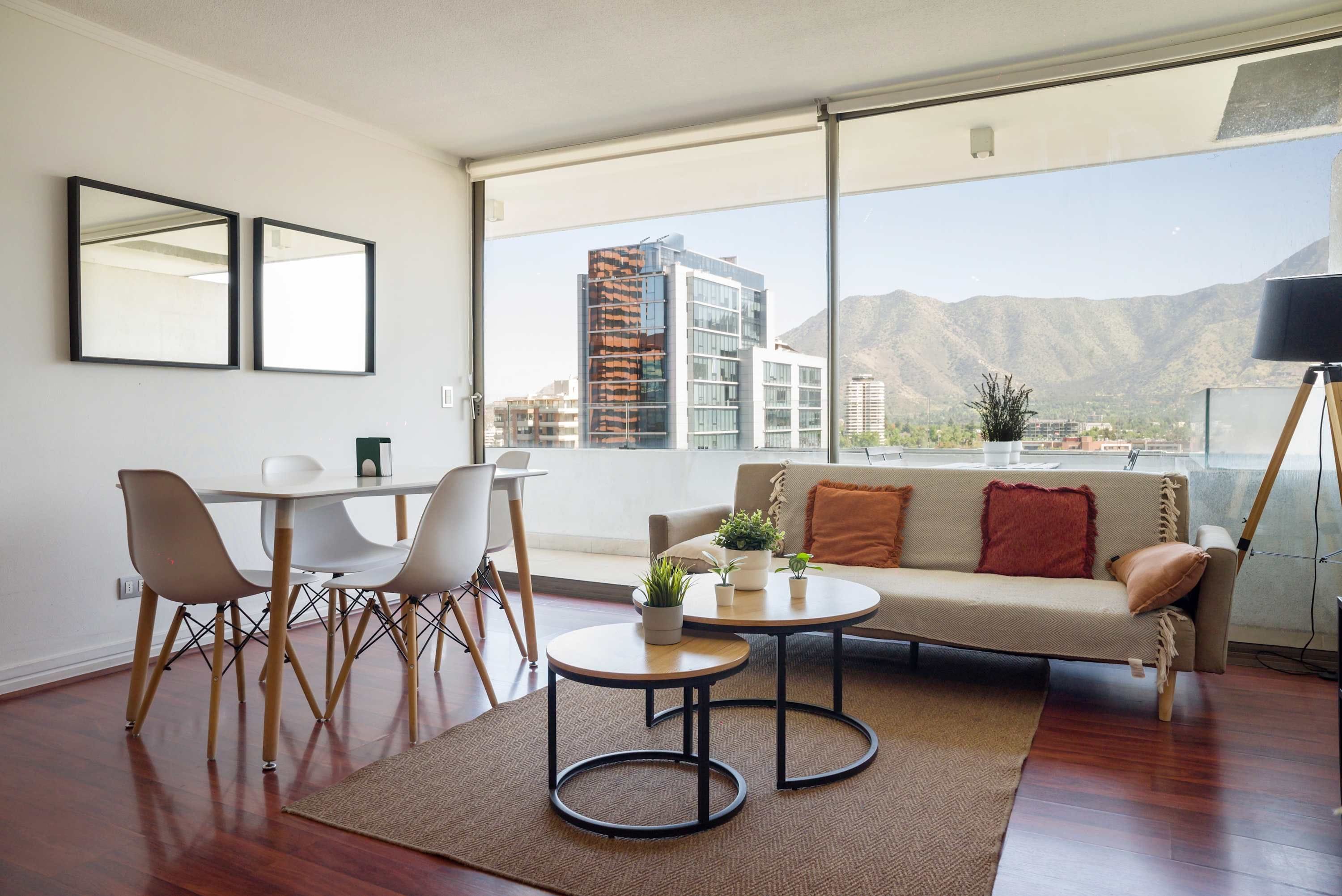 Uma sala de estar moderna com sofá, mesa de centro e área de refeições.