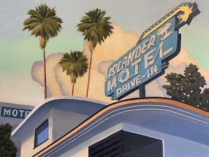 Placa de motel com palmeiras ao fundo.
