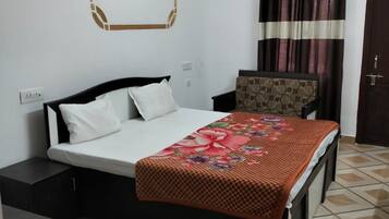 Quarto com cama, cadeira, guarda-roupa, janela com cortinas e decoração na parede.