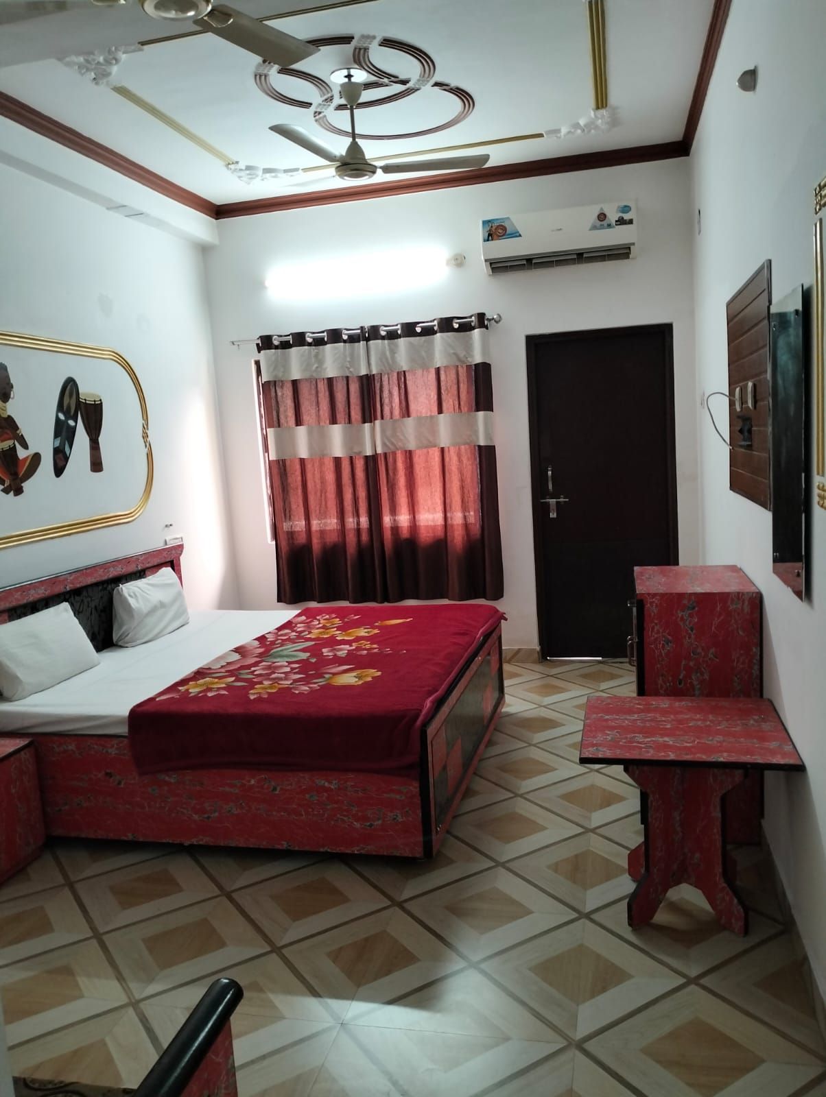 Quarto com cama, cadeira, guarda-roupa, porta e ventoinha no teto.