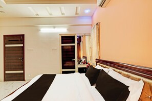 Quarto de hotel com cama, guarda-roupa e espelho.
