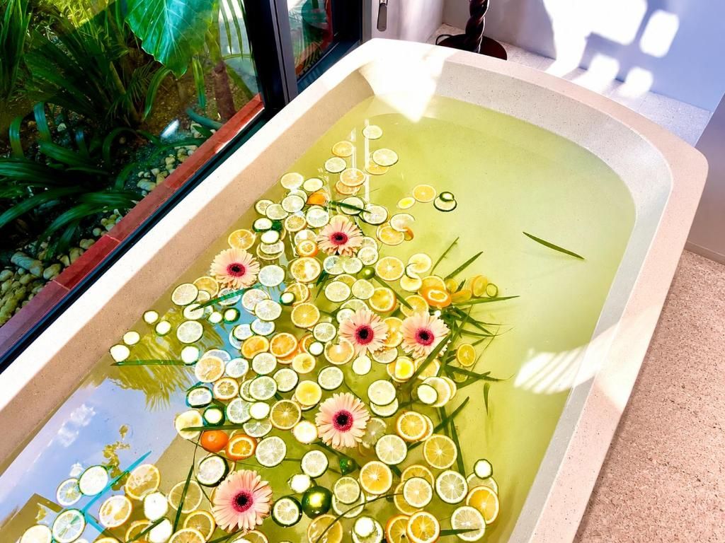 Uma fonte retangular com fatias de cítricos e flores diversas.