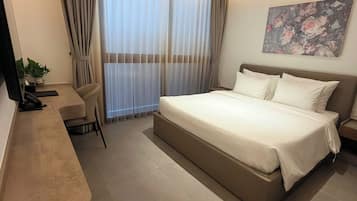 Quarto de hotel moderno com uma cama grande, uma escrivaninha e uma cadeira.