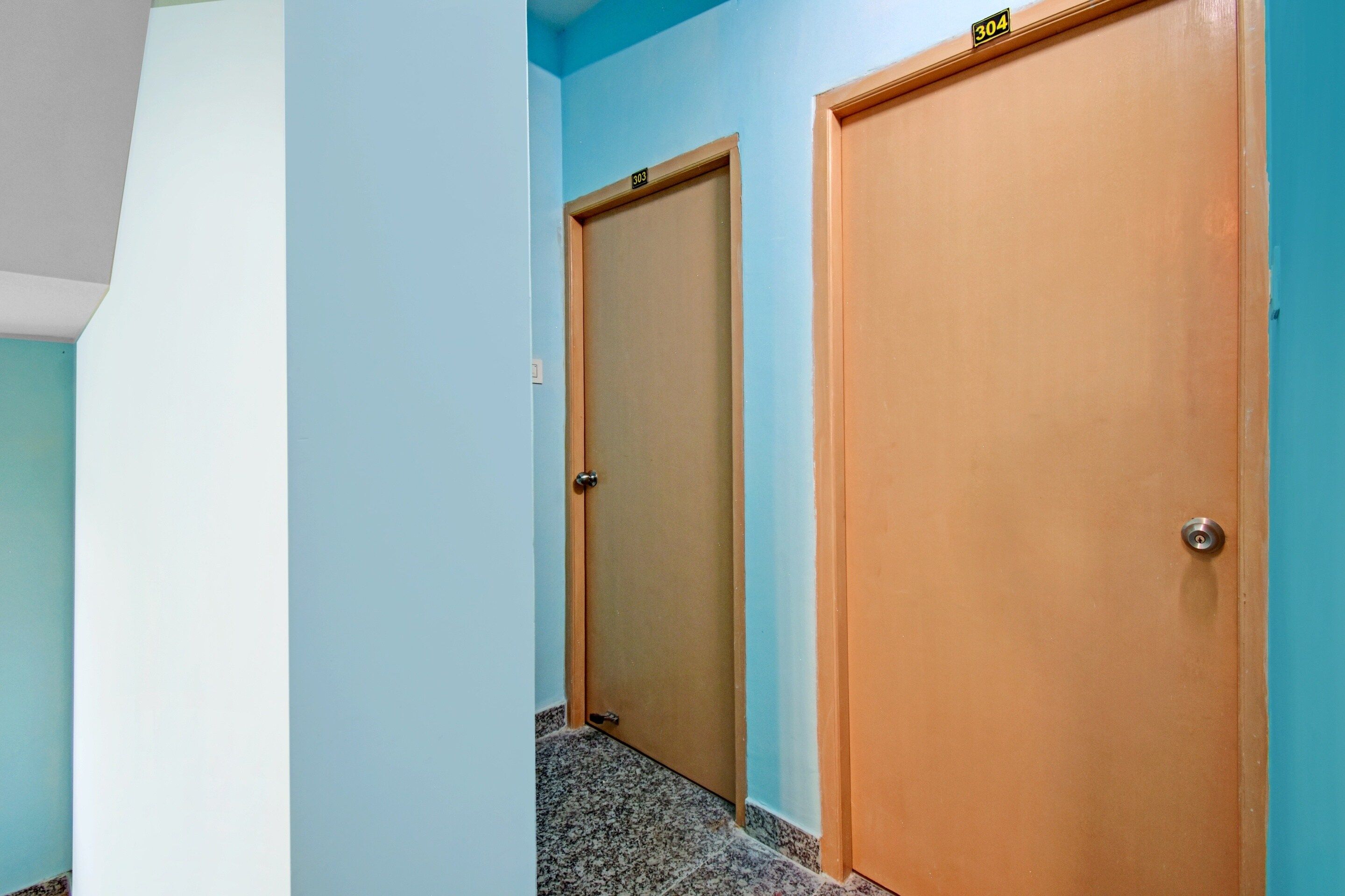 Corredor com duas portas, uma com a inscrição 303 e outra com 304, dando acesso a quartos vizinhos.