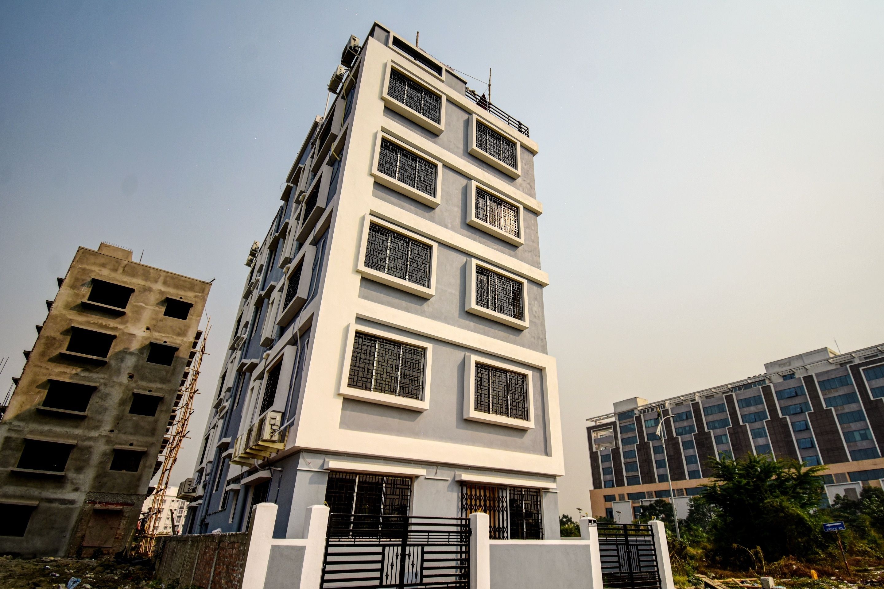 Um edifício de vários andares com design arquitetônico moderno, com uma série de janelas com grades de metal.