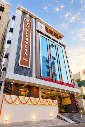 Um hotel moderno com uma placa de destaque exibindo 'TUNGUNTLAS' e 'HOTEL MOOONLIGHT' na fachada.