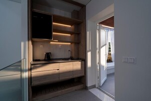 Cozinha moderna com eletrodomésticos embutidos, bancada de madeira e vista para o exterior por uma porta de correr.