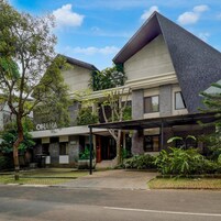 Um edifício moderno de dois andares com entrada coberta e telhado inclinado.