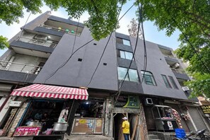 Um edifício com vários andares e fachada comercial no nível térreo.