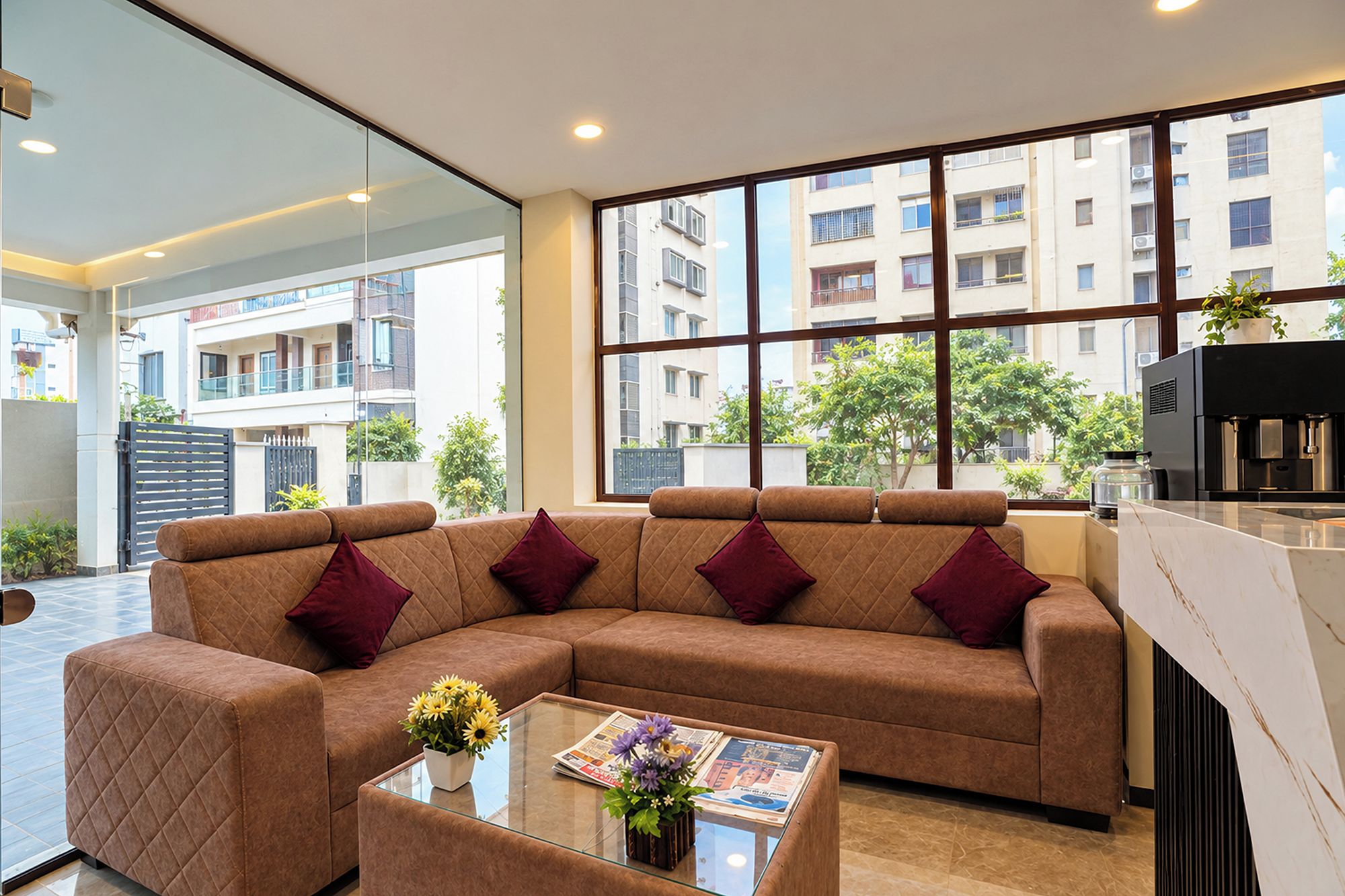 Sala de estar moderna com sofá em formato de L, mesa de centro de vidro e vista para um prédio residencial por grandes janelas.