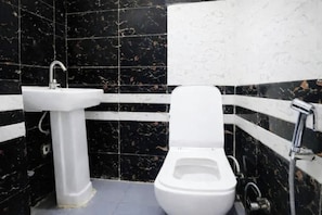 Casa de banho com lavatório pedestal branco e sanita branca.