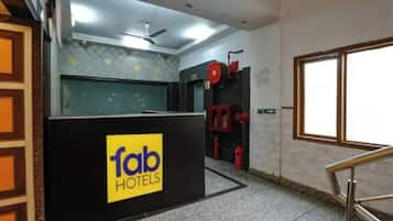 Uma receção com o logotipo 'fab hotels' e um extintor fixado na parede.