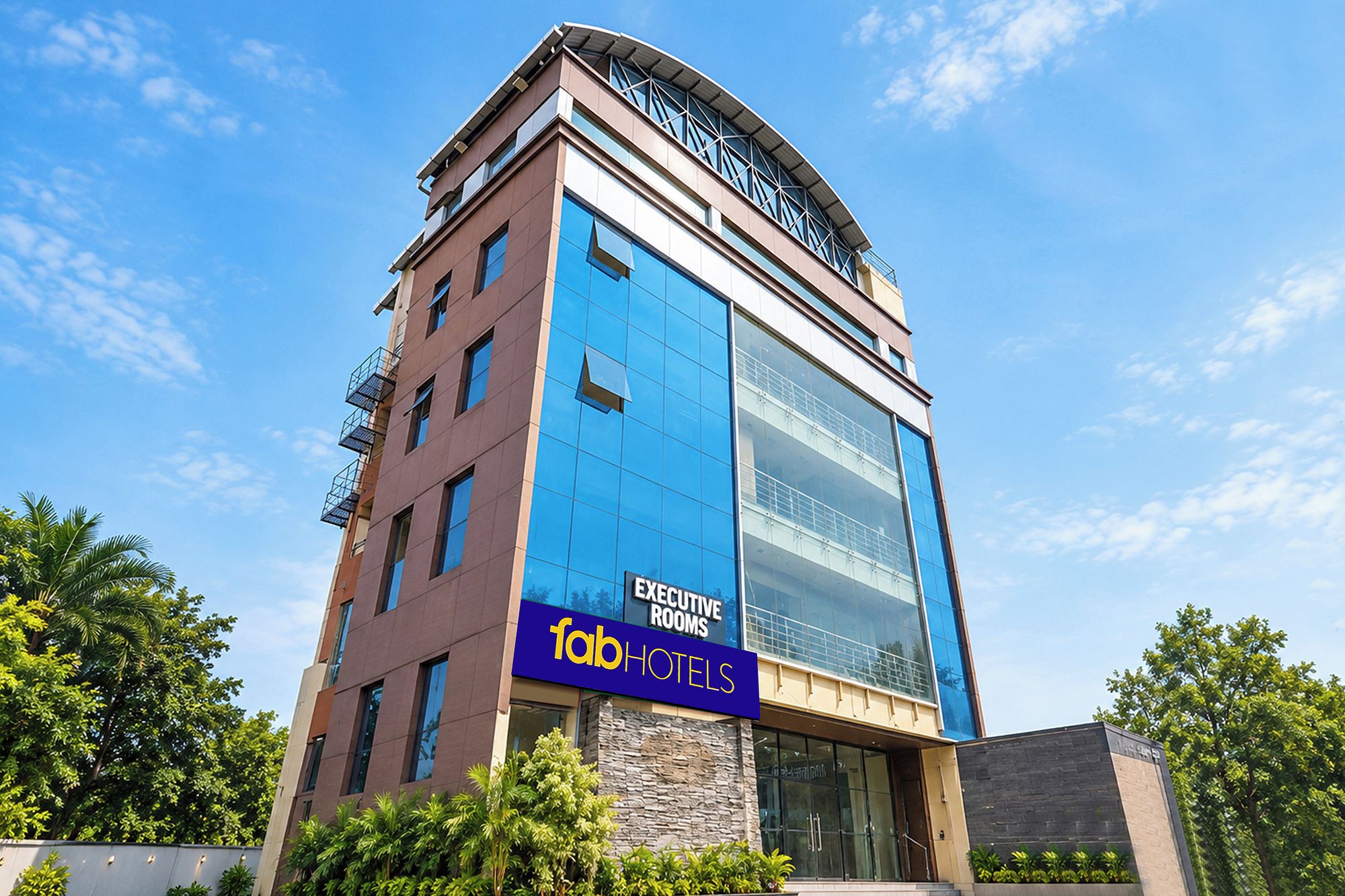Edifício de hotel com placa indicando quartos executivos e logotipo 'fab hotels'.