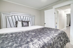 Quarto com cama, cabeceira e porta.