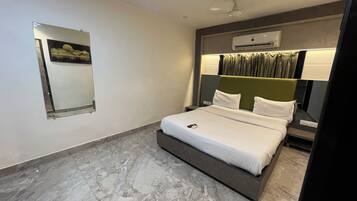Quarto de hotel com cama, espelho, ar condicionado e piso de mármore.