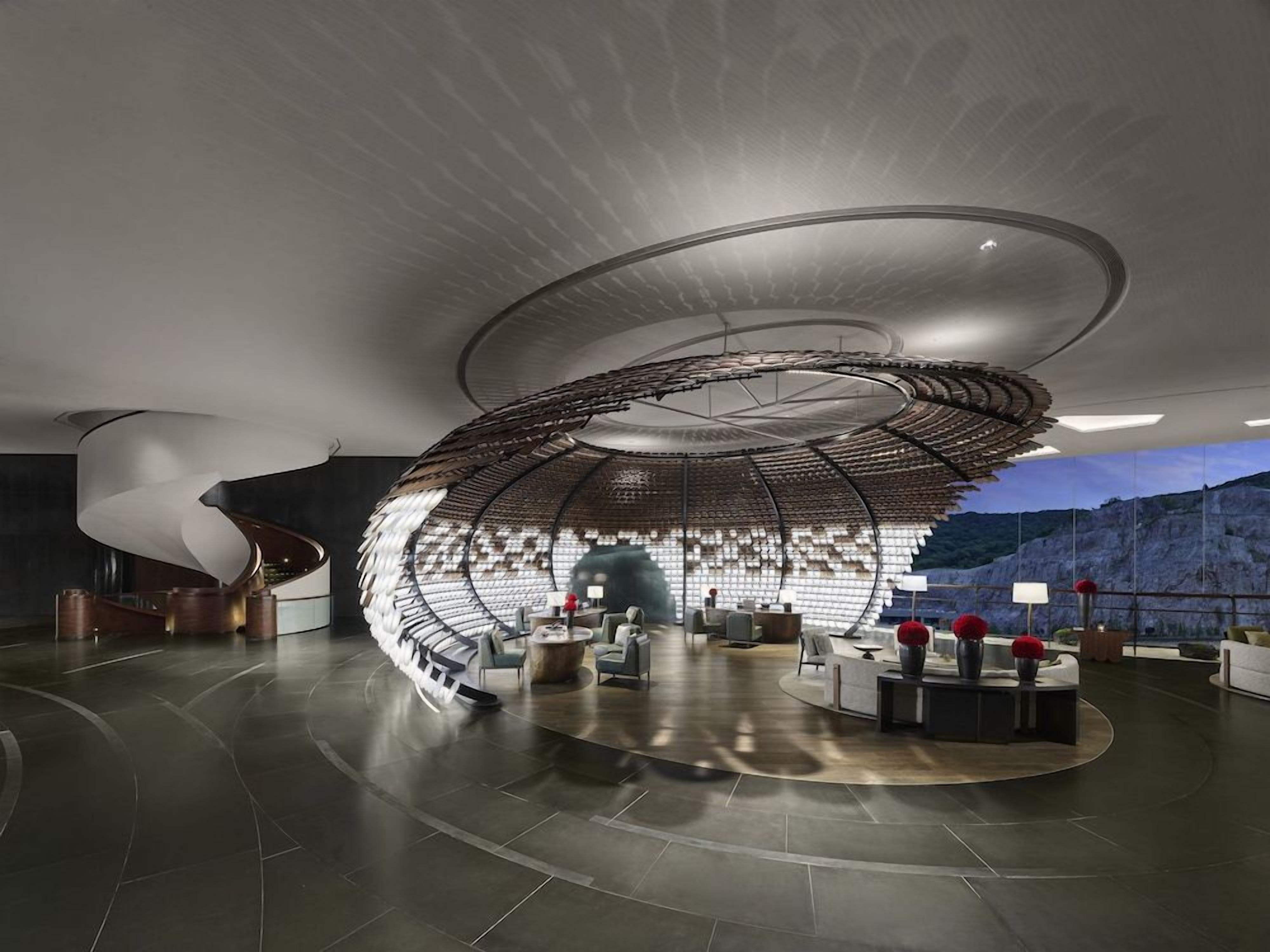 Um interior moderno com uma área de estar circular, uma escada em espiral e vista para o exterior.