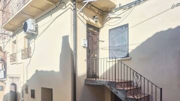 Um edifício residencial com escadas, uma porta e um aparelho de ar condicionado.