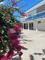 Um edifício com design moderno, apresentando fachada de vidro e uma varanda.