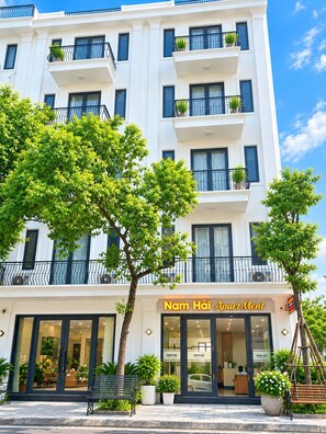Um edifício de vários andares com uma placa indicando 'Nam Hai Apartment'.
