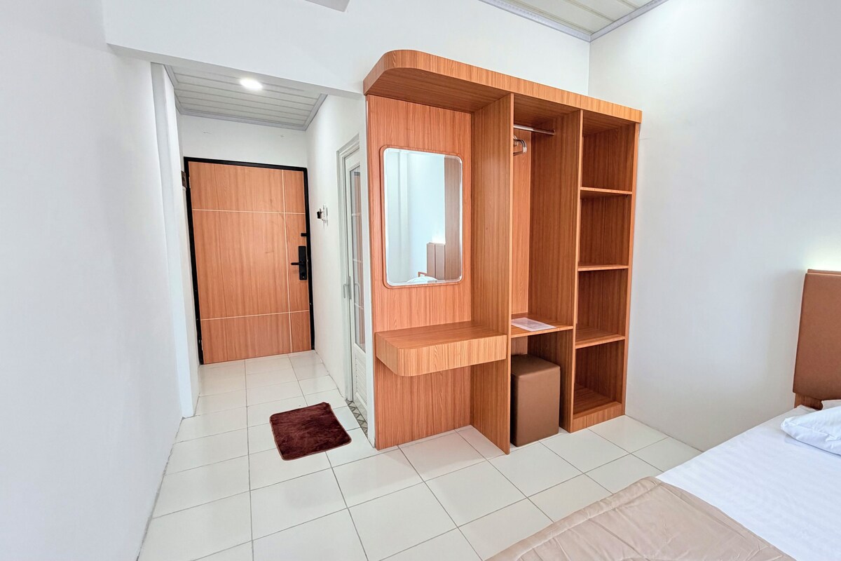 Quarto com cama, guarda-roupa e espelho.