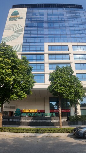 Um edifício moderno com uma placa visível para o Hospital Sungroup International.