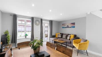 Uma sala de estar moderna com sofá, mesa de centro e área de jantar.