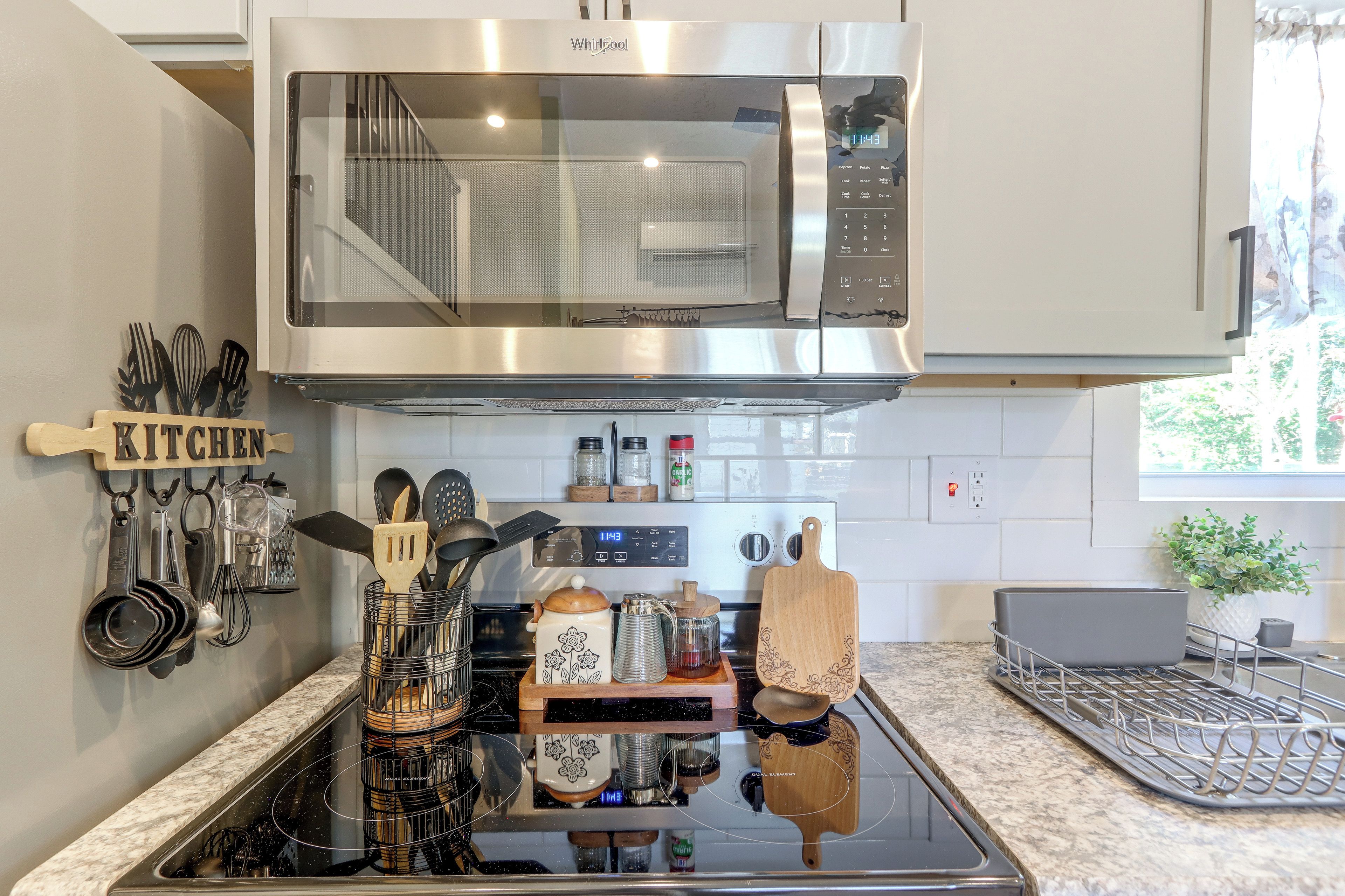 Cozinha equipada com micro-ondas, fogão e diversos utensílios.