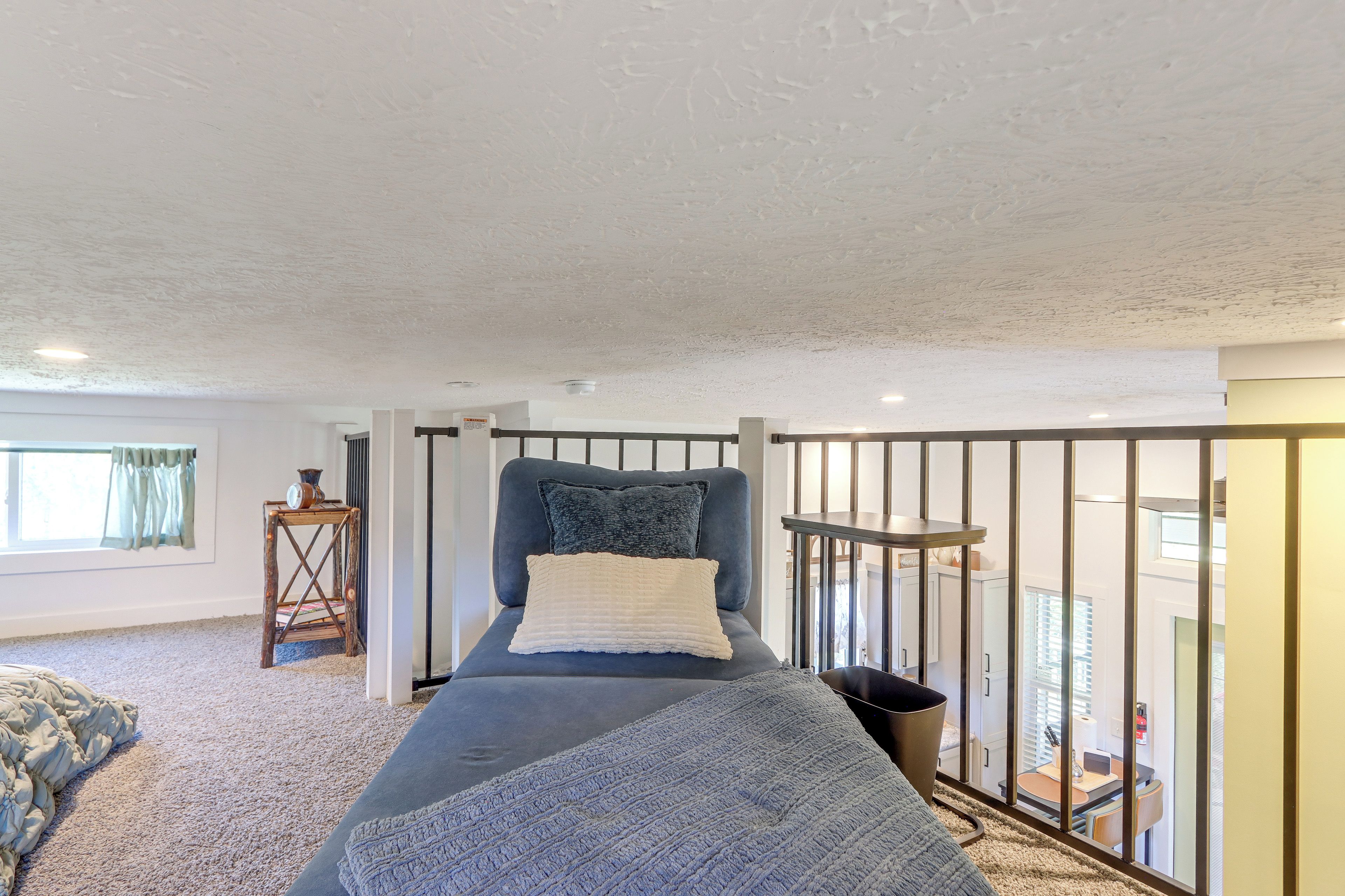 Quarto com cama, janela e varanda.