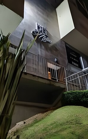 Um edifício com uma grande placa com a palavra 'Cielo' e uma varanda com grade de metal.