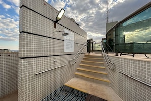 Uma escadaria de azulejos que leva a uma varanda com vista para o céu e nuvens.